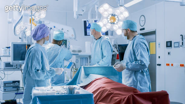 Diverse Team of Professional surgeon, Assistants and Nurses Performing ...