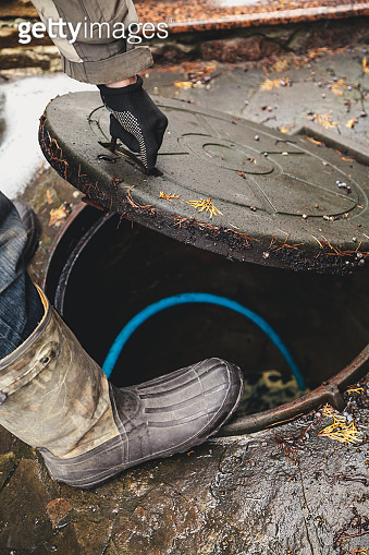 hand opens sewer hatch in yard (916873610) - 게티이미지뱅크