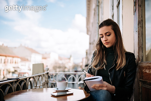 Image of a female journalist writting while enjoying a cup of coffee on ...