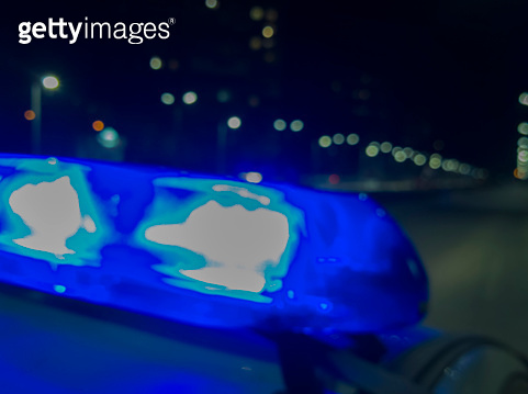 Flashing blue lights of a police car on city background, crime scene ...