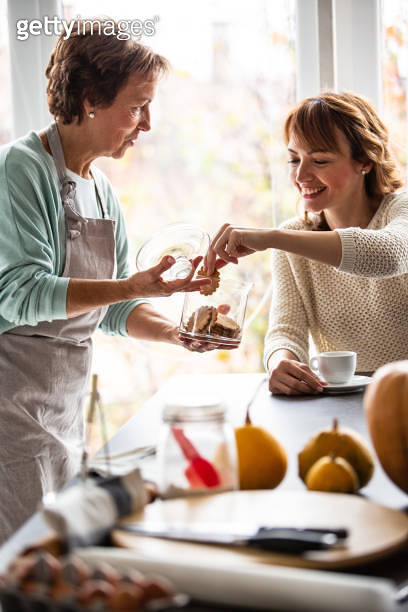 Senior woman giving cookie to her adult daughter 이미지 (1082560810) - 게티이미지뱅크