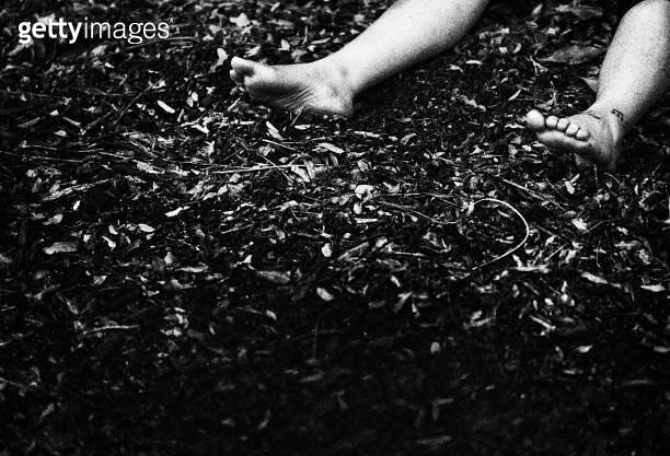 Female feet, part of a dead body, lying in leaves (1077551038) - 게티이미지뱅크