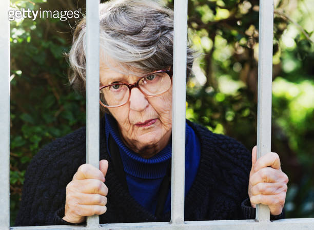 Aging concept: Old woman trapped behind gate 이미지 (1015288410) - 게티이미지뱅크