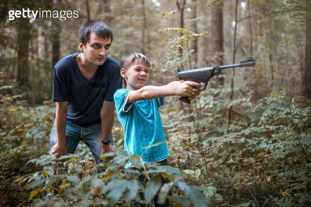 Man Teaches boy How To Shoot From Air Gun 이미지 (1047038704) - 게티이미지뱅크