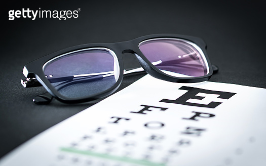 Eye test and sight exam concept. Glasses on letter chart. Eyeglasses on ...