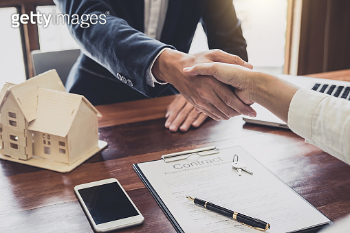 Real estate agent and customers shaking hands together celebrating ...