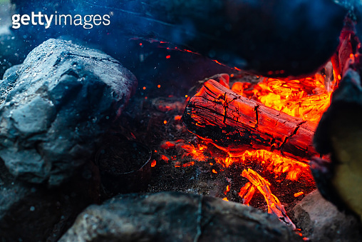 Smoldered logs burned in vivid fire close up. Atmospheric background ...