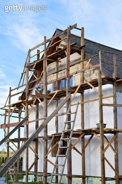 Wooden scaffolding next to white unfinished residential house 이미지 ...