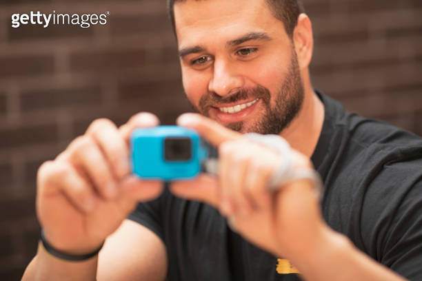 Handsome bearded man filming with action camera, using a GoPro on ...