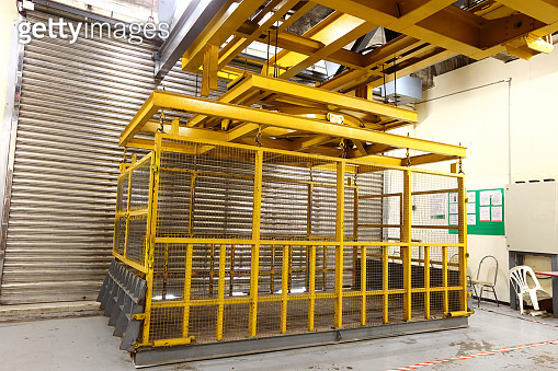 Yellow Elevator in loading bay to load heavy machine inside building ...