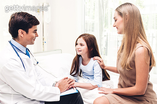 Doctor holding hand little girl with care on doctors table in hospital ...