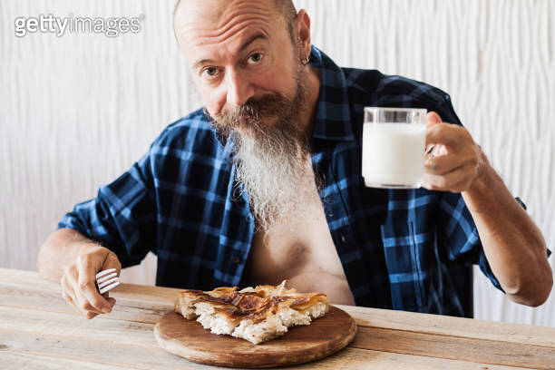 Middle aged man eating breakfast - Turkish borek, asian cuisine ...