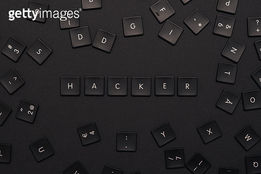 The word 'hacker' assembled from black keyboard keys on a dark ...