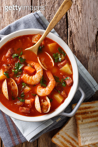 Manhattan tomato clam chowder soup close-up in a saucepan. Vertical top ...