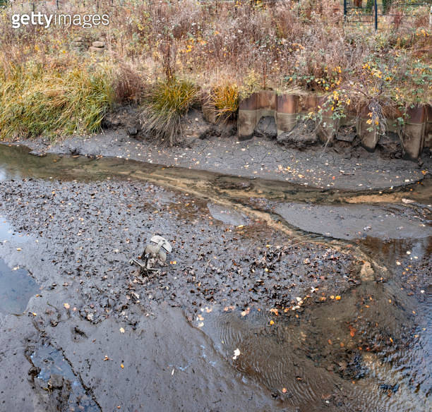 Litter And Pollution On A Muddy River Bed 이미지 (981094658) - 게티이미지뱅크