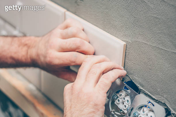Tile installs an electrical outlet in a round tile hole 이미지 (1014225264 ...