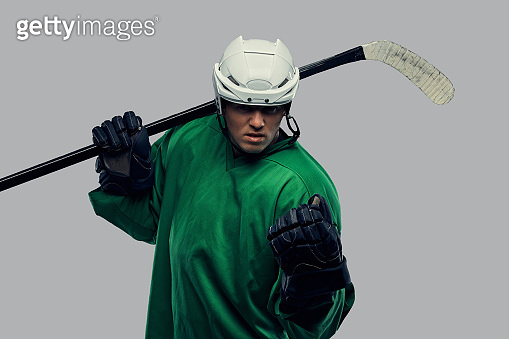 Angry professional hockey player in green sportswear standing with a ...