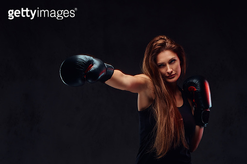Beautiful brunette female boxer during boxing exercises, focused on a ...