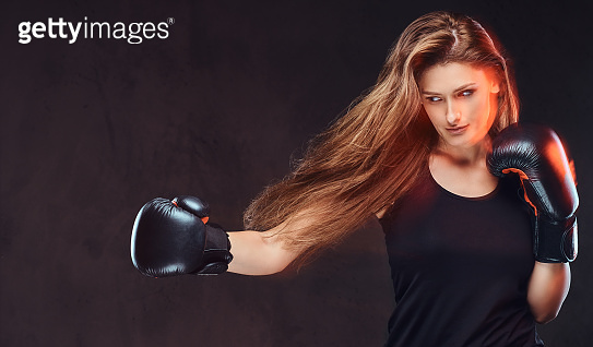 Beautiful brunette female boxer during boxing exercises, focused on a ...