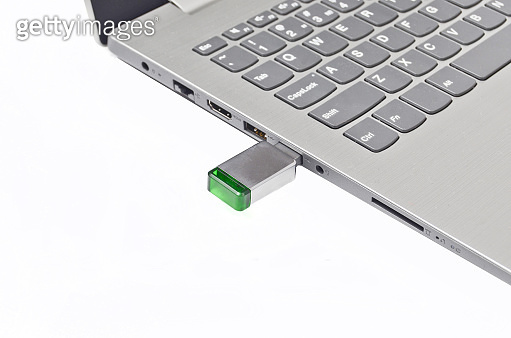 USB flash drive inserted into a laptop isolated on a white background ...