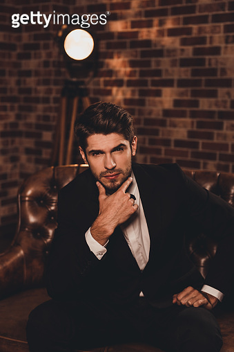 Portrait of confident harsh man in black suit sitting on sofa 이미지 ...