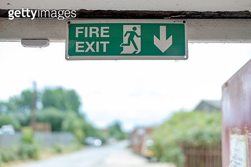 Shallow focus, isolated image of a green Fire Exit sign seen attached ...