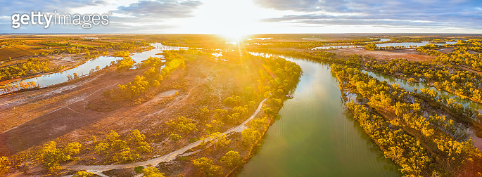 Aerial panorama of bright sun flare at sunset over Murray River in ...
