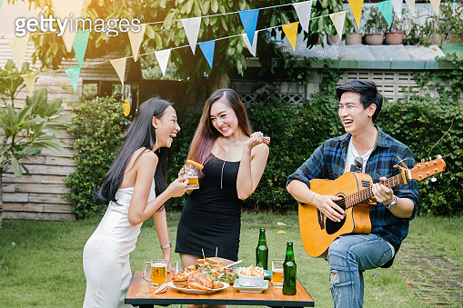 Group of friends having party in home garden.Happy young mates enjoying ...