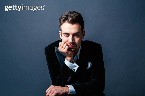 Portrait of a serious young handsome man dressed in black, dramatic ...