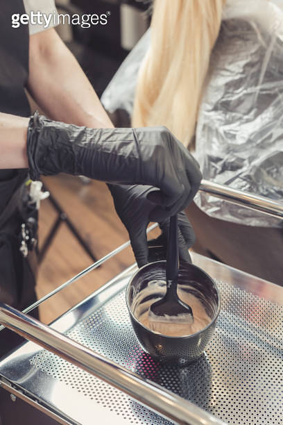 Hair stylist hands preparing a dye in a container (1054997362) - 게티이미지뱅크