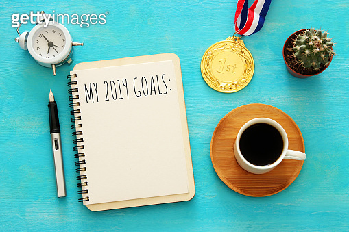 Top view 2019 goals list with notebook, cup of coffee over wooden desk ...
