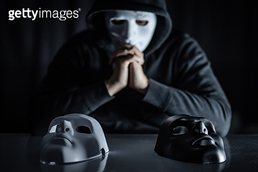 Mystery Hoodie man wearing broken white mask looking at black and white ...