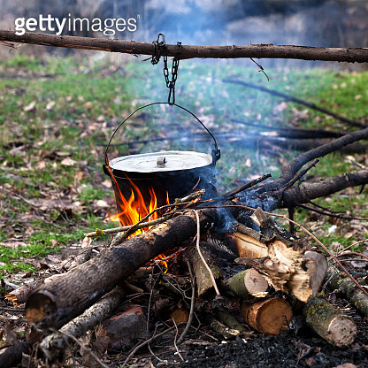 Cooking in old sooty cauldron on campfire 이미지 (1189445128) - 게티이미지뱅크