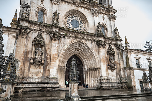 People walk in the rain in front of Alcobaca Monastery, Portugal ...