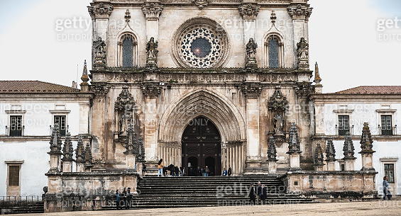 People walk in the rain in front of Alcobaca Monastery, Portugal ...