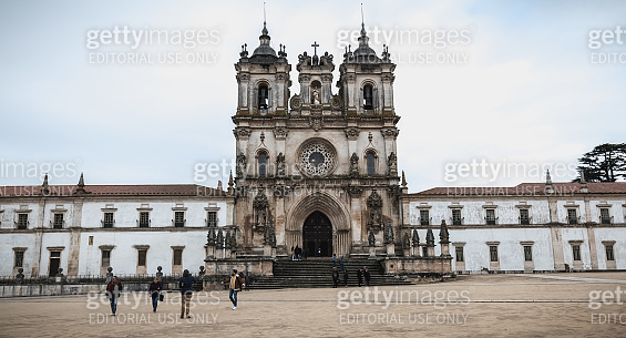 People walk in the rain in front of Alcobaca Monastery, Portugal ...