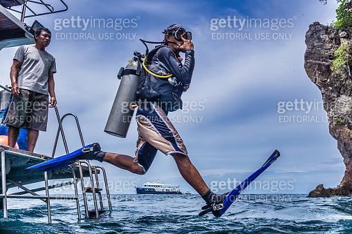 Scuba Diver jumping off boat demonstrating perfect giant stride entry ...