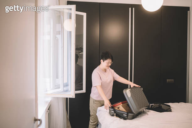an asian chinese female packing her luggage in the room before the ...