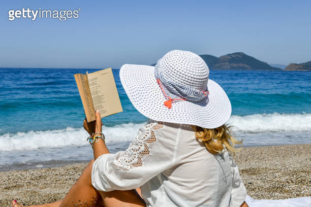 Woman studying book at the beach. 이미지 (1156686739) - 게티이미지뱅크