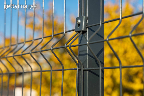 Steel grating fence made with wire on blue sky background. Sectional ...
