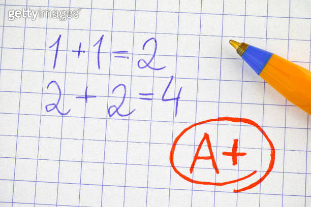 A plus (A+) grade on notebook paper sheet with math operation solved ...