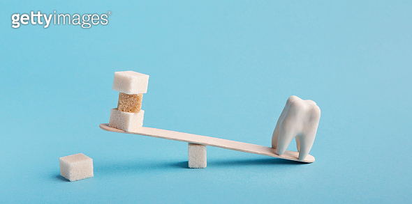 Healthy tooth and sugar balancing on seesaw swing 이미지 (1092692442) - 게티 ...