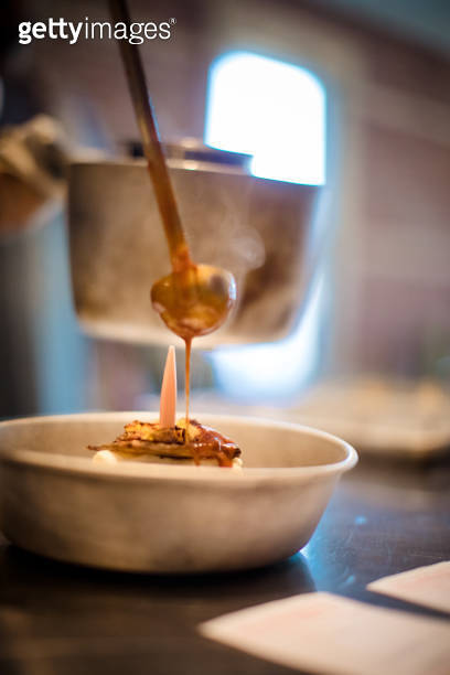 Young Chef Pouring Gravy On Potato Fries and cheese curds. Canadian ...