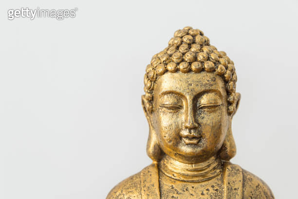 Generic golden statue of Buddha on white wall background. Interior ...