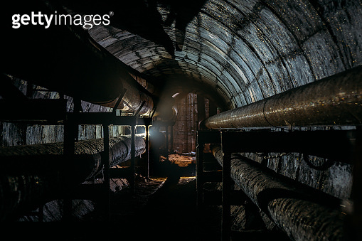 Round concrete underground tunnel of heating duct system with rusty ...