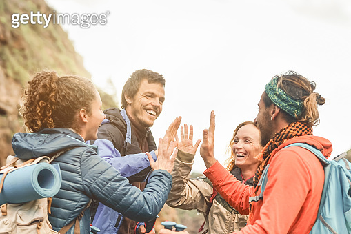 Group of friends stacking hands while doing trekking excursion on ...