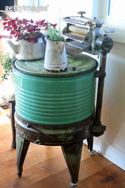 Old, antique washing machine displayed with colorful flowers in antique ...