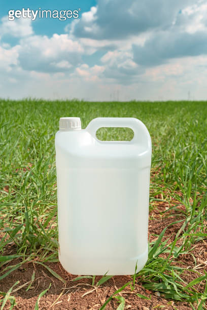Blank pesticide jug container mock up in wheatgrass field (1147389892 ...