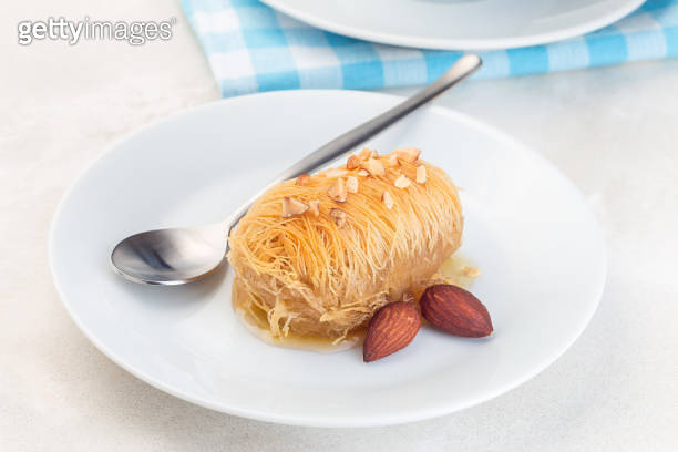 Greek pastry Kataifi with shredded filo dough stuffed with almond nuts ...
