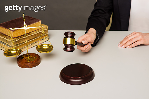 Cropped image of judge giving verdict by hitting mallet at desk 이미지 ...